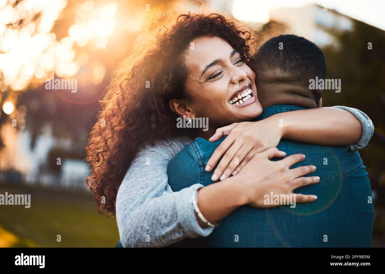 In your embrace is where I find my happy place. a young woman hugging her boyfriend outdoors ...