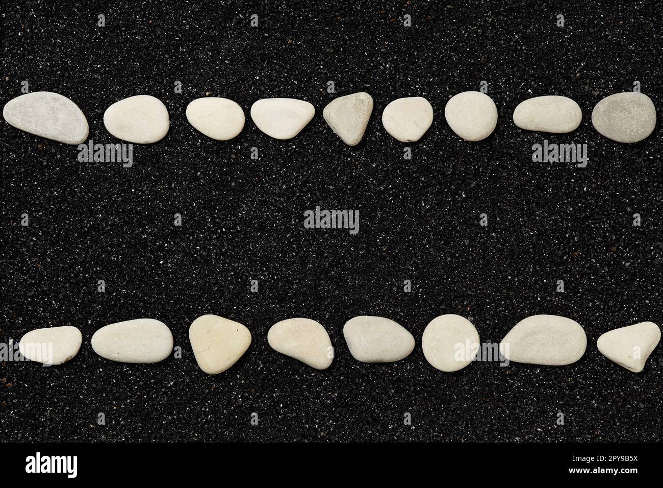 Black beach sand with lines of pebbles. Travel and vacations concept ...