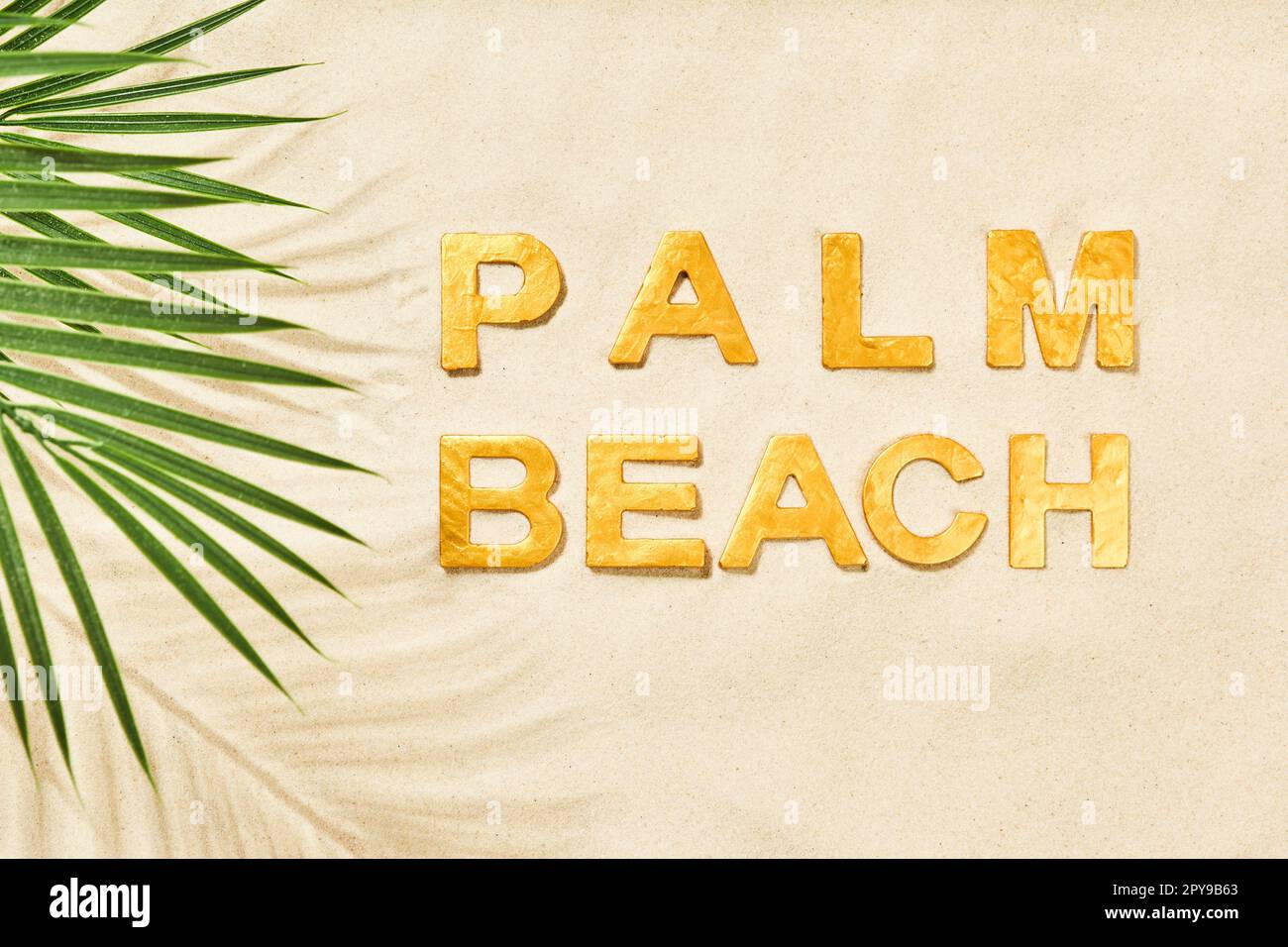 Palm Beach - Gold letters in the sand and palm leaves Stock Photo - Alamy