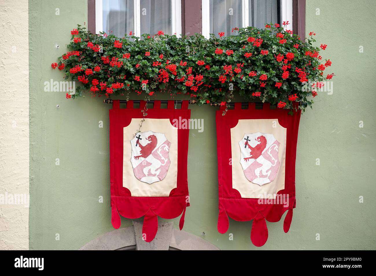 Red geraniums and flags on a house in Rothenburg Stock Photo - Alamy