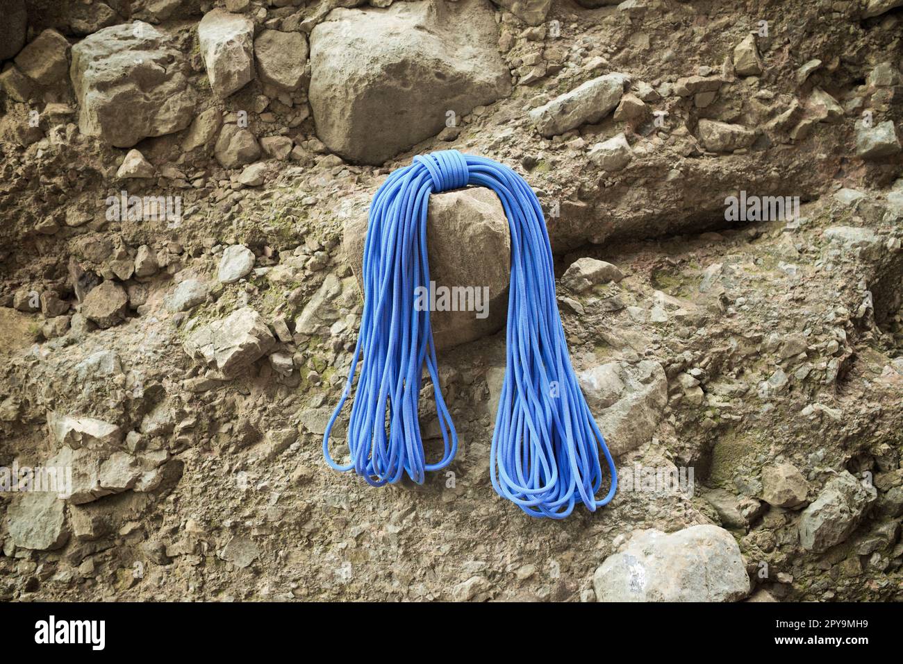 Blue climbing rope leaning against a rock face in Mallos de Riglos ...