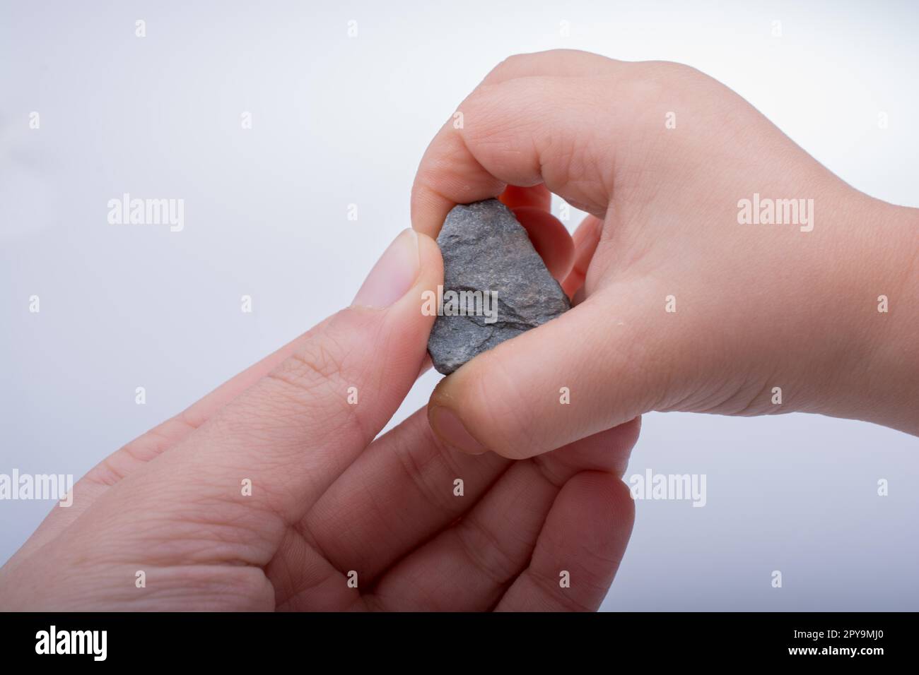 Hand holding little stone in hi-res stock photography and images - Alamy