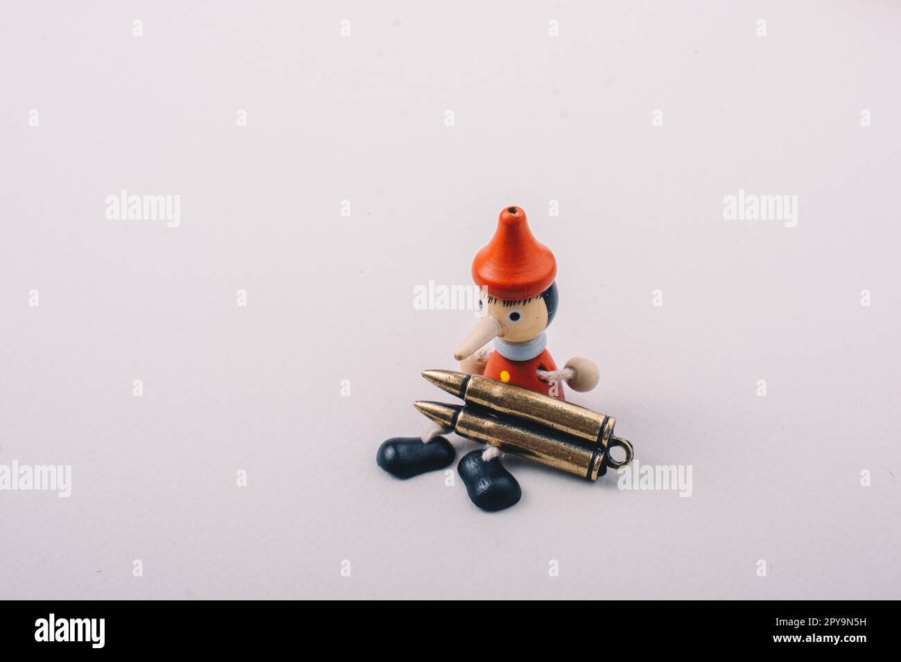 Bullet and wooden pinocchio doll with his long nose Stock Photo - Alamy
