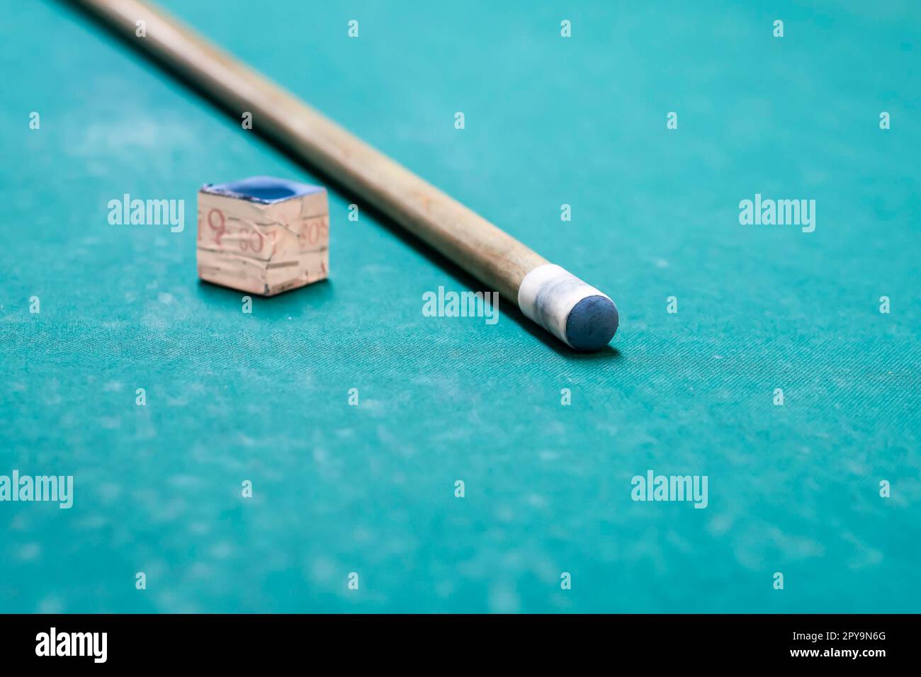 A cue stick and a chalk on a pool table Stock Photo - Alamy