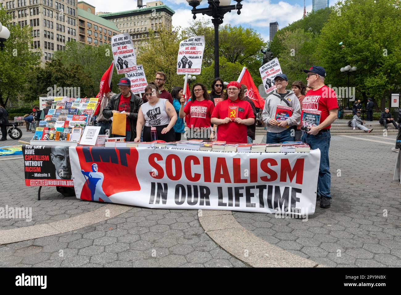 A group of people holding signs and flags, standing together in a ...