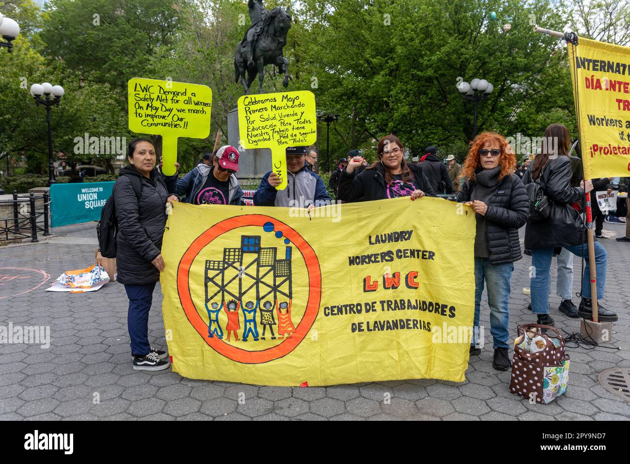A group of people holding signs and flags, standing together in a ...