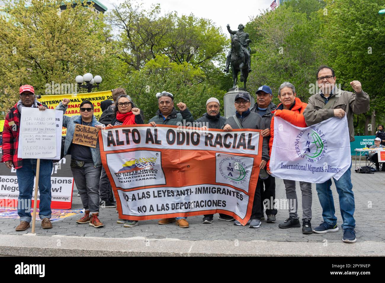 A group of people holding signs and flags, standing together in a ...