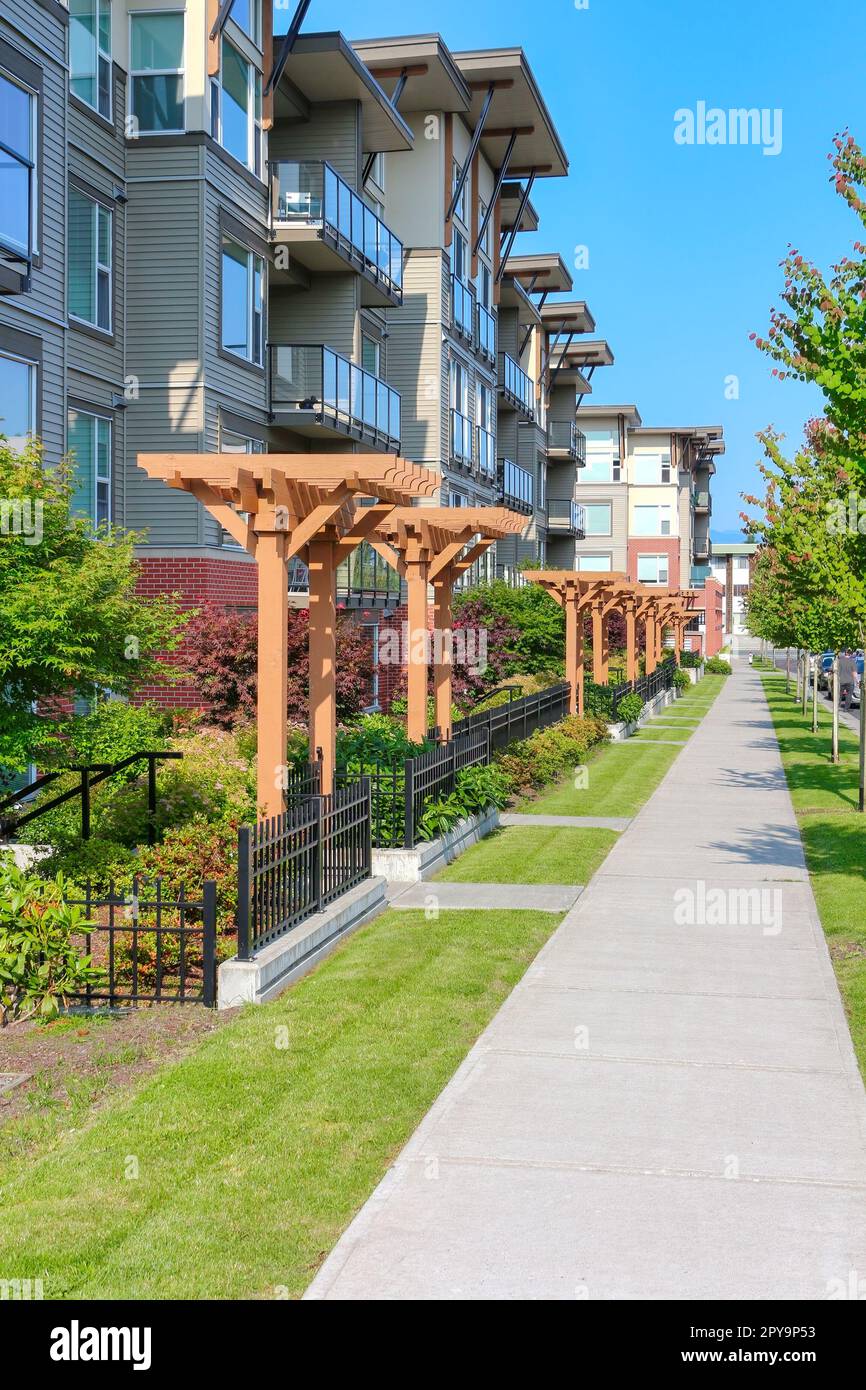 Paved walkway along the residential building on a bright sunny day ...