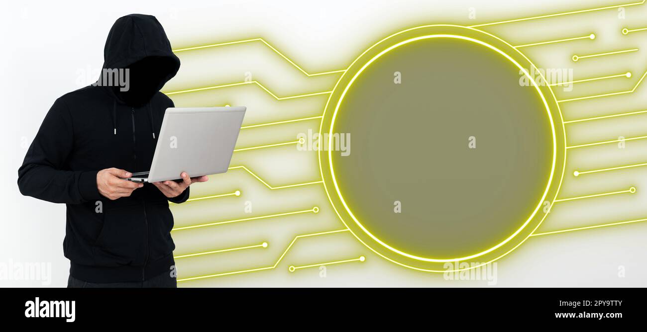 Male programmer in black hoodie stands and holds laptop. Hacker with ...