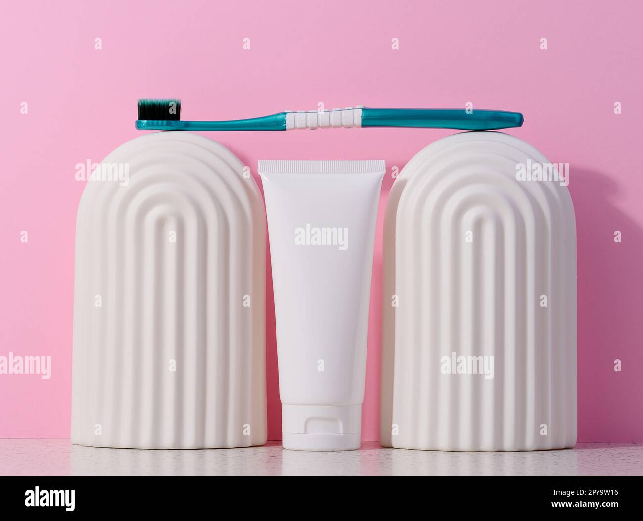 White plastic toothpaste tube and toothbrush on a pink background Stock ...