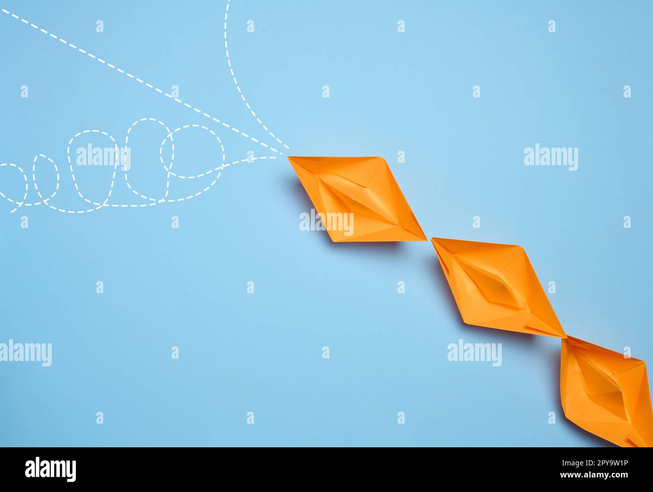 Paper boats on a blue background, representing the concept of ...