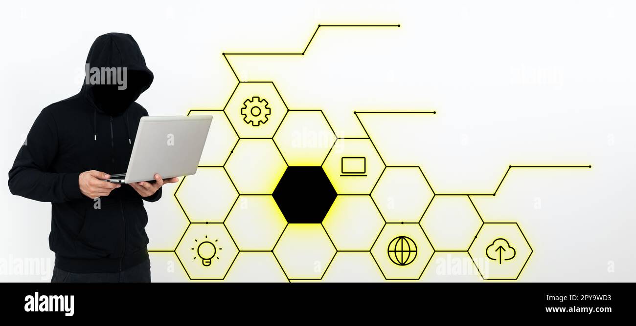 Male programmer in black hoodie stands and holds laptop. Hacker with ...