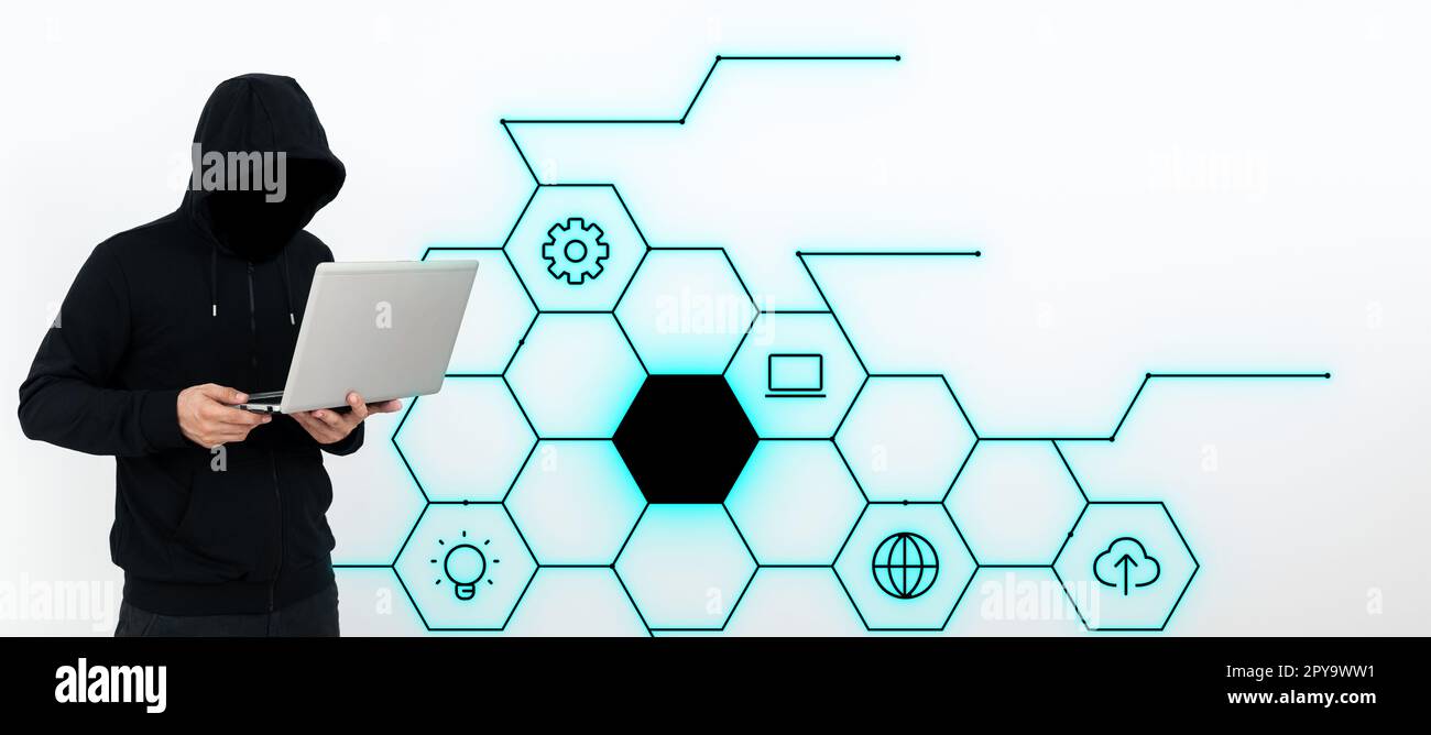 Male programmer in black hoodie stands and holds laptop. Hacker with ...