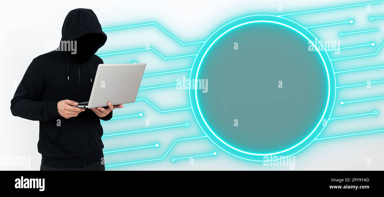 Male programmer in black hoodie stands and holds laptop. Hacker with ...