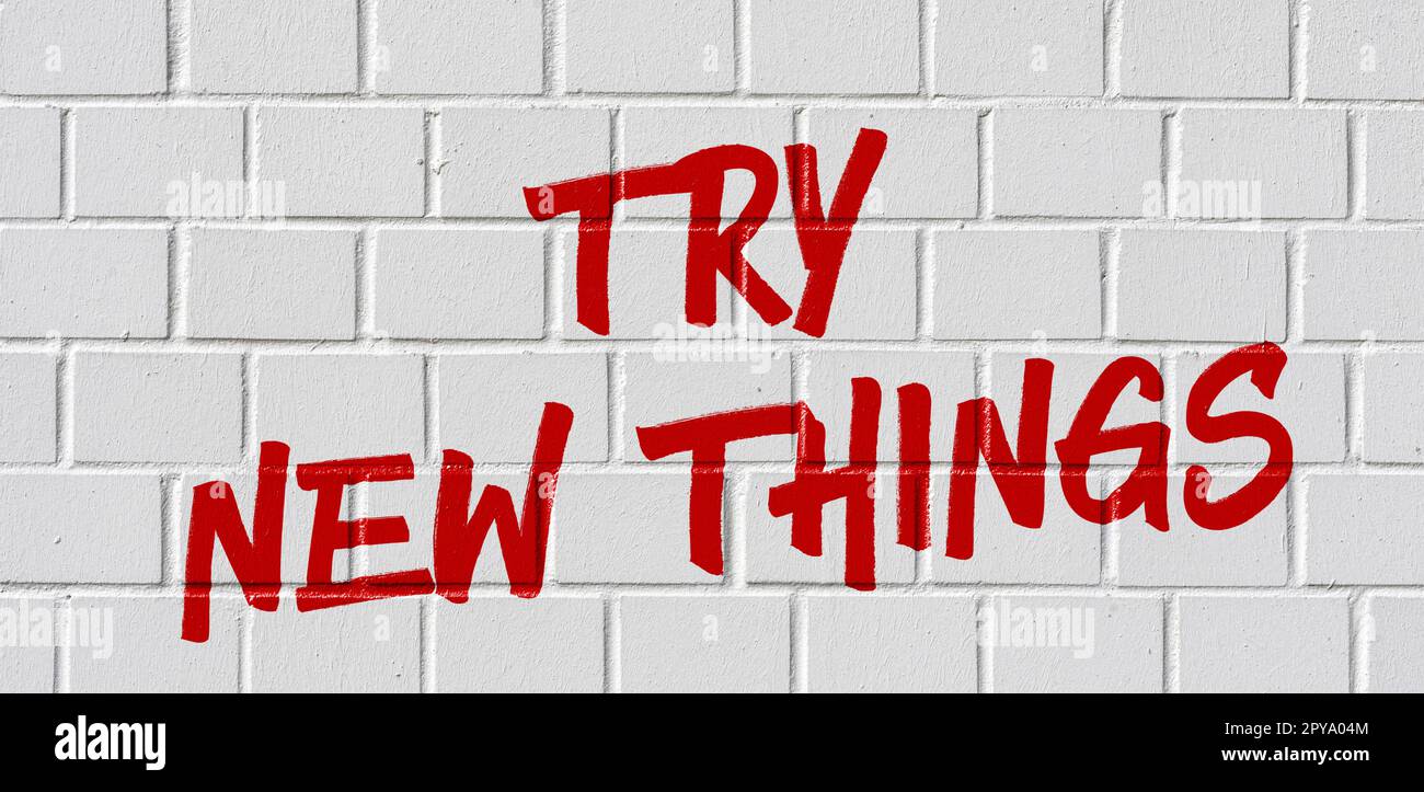 Graffiti on a brick wall - Try new things Stock Photo - Alamy