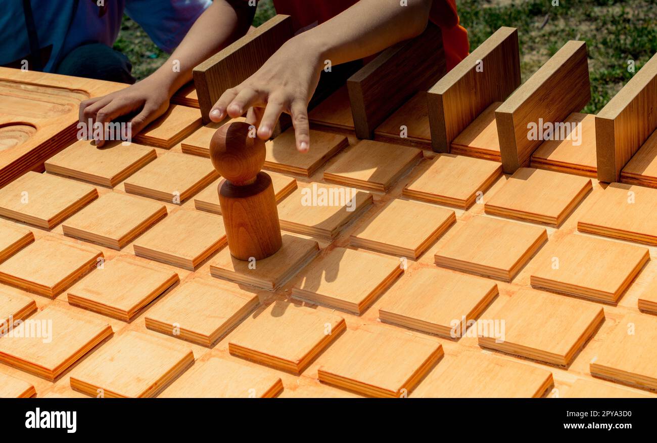 Hand holding wooden puzzle element in hand Stock Photo - Alamy