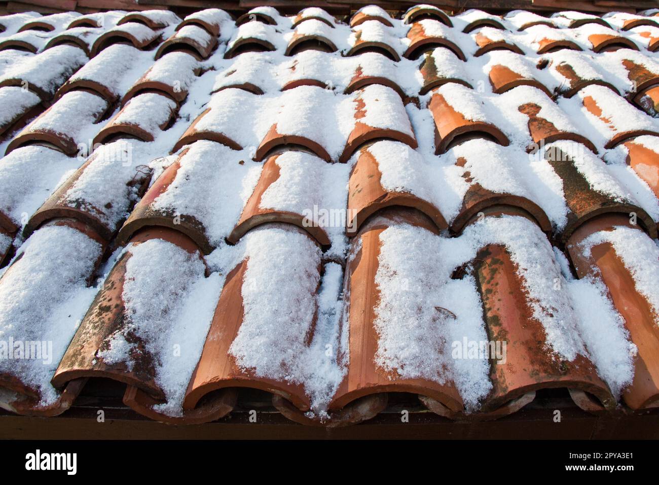 Brown tiles slightly covered with white snow Stock Photo - Alamy