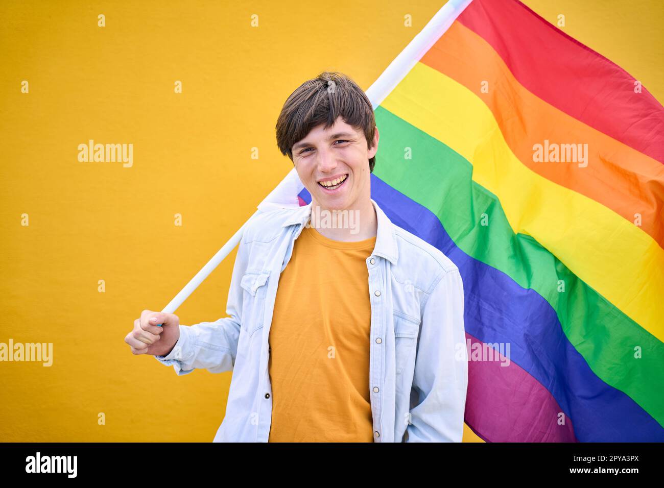 Smiling happy young Caucasian holding lgbt rainbow flag. Homosexual ...
