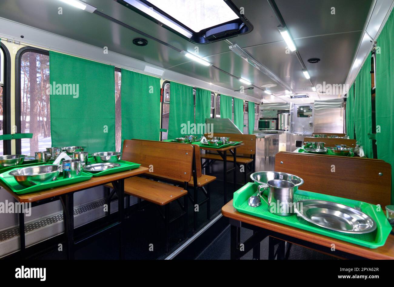Interior of mobile canteen for soldiers, accommodated in a bus: tables ...