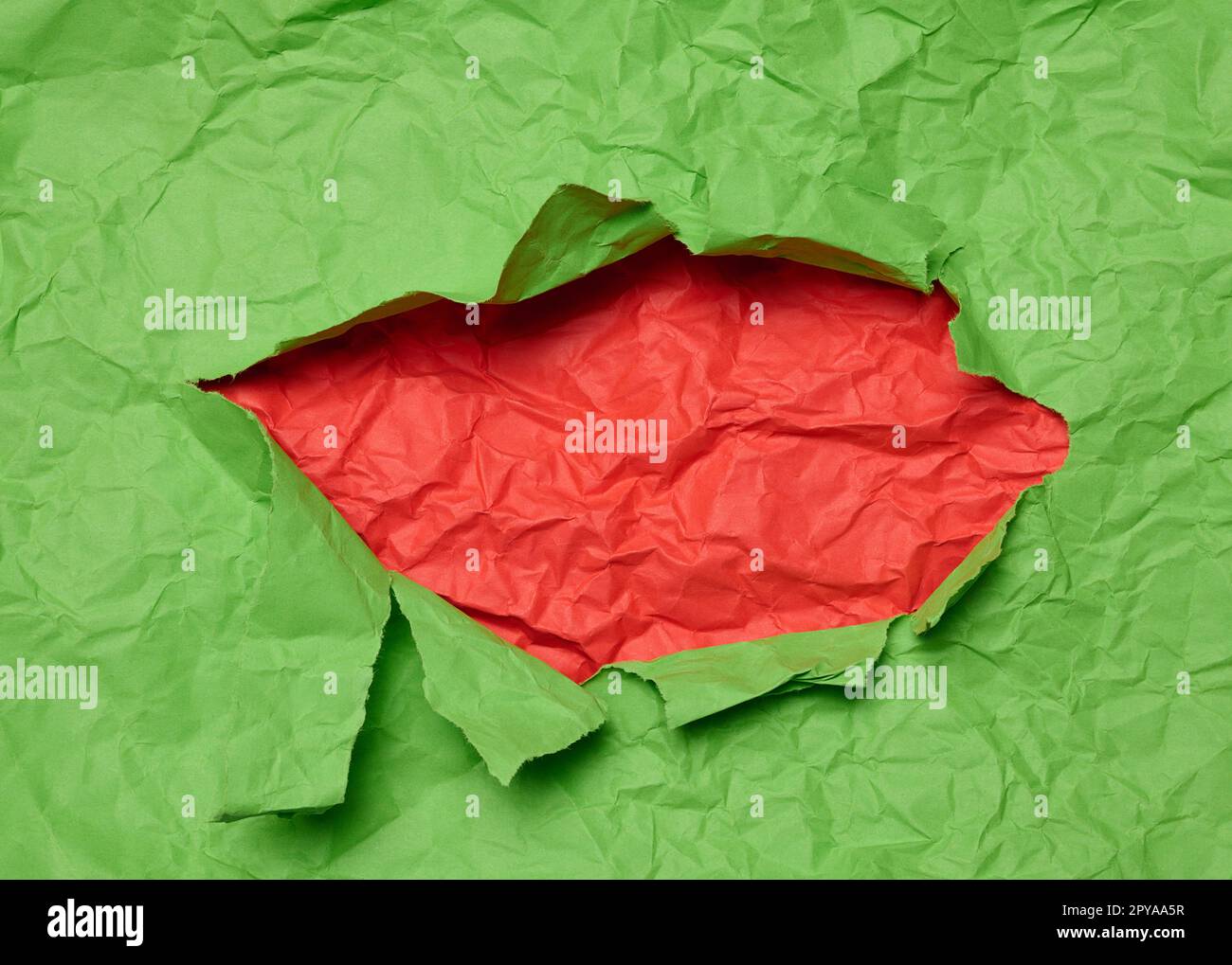 Texture of green paper with torn hole and red background, template for ...