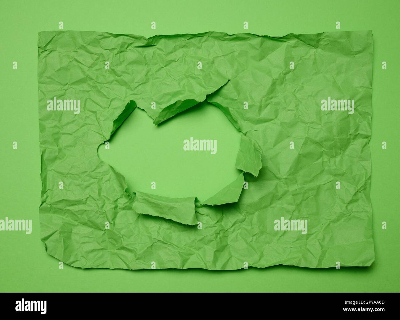 Texture of crumpled green paper with torn hole and green background ...