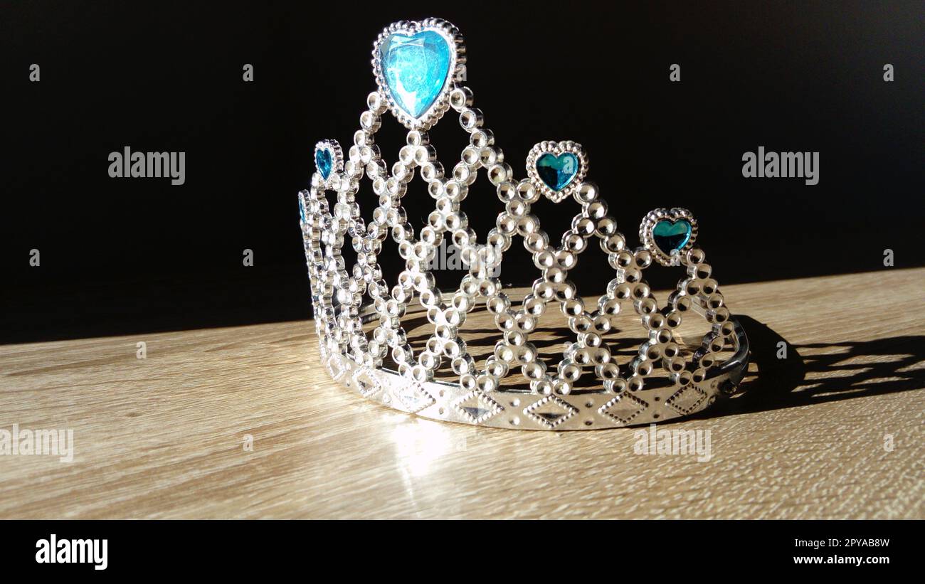a crown with a blue stone shines in side lighting Stock Photo - Alamy