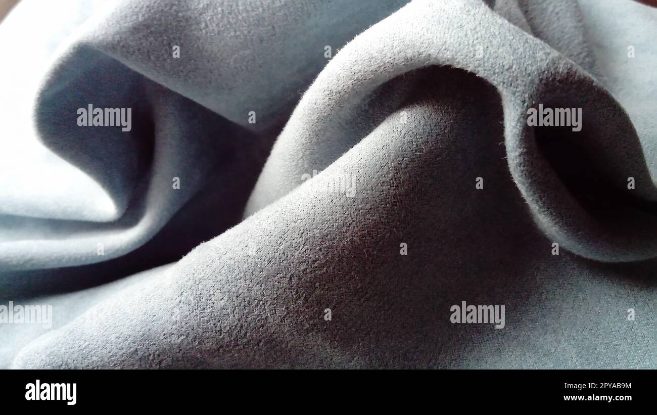 A close-up of a velvety dense fabric for curtains of gray-blue color ...