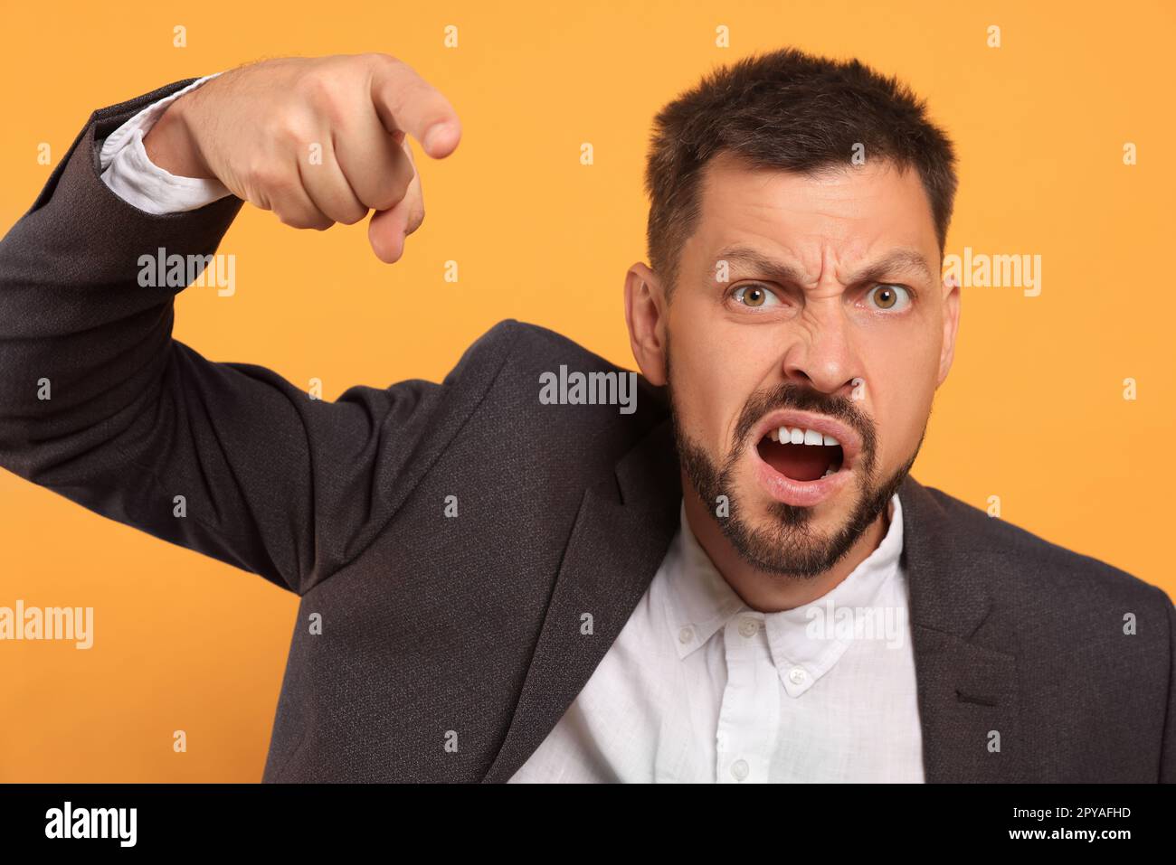 Aggressive man pointing on orange background. hate concept Stock Photo ...