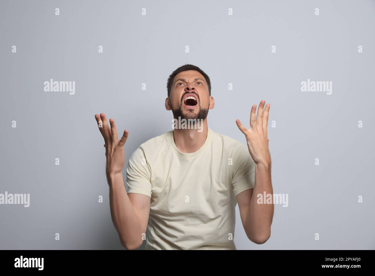 Aggressive man shouting on grey background. Hate concept Stock Photo ...