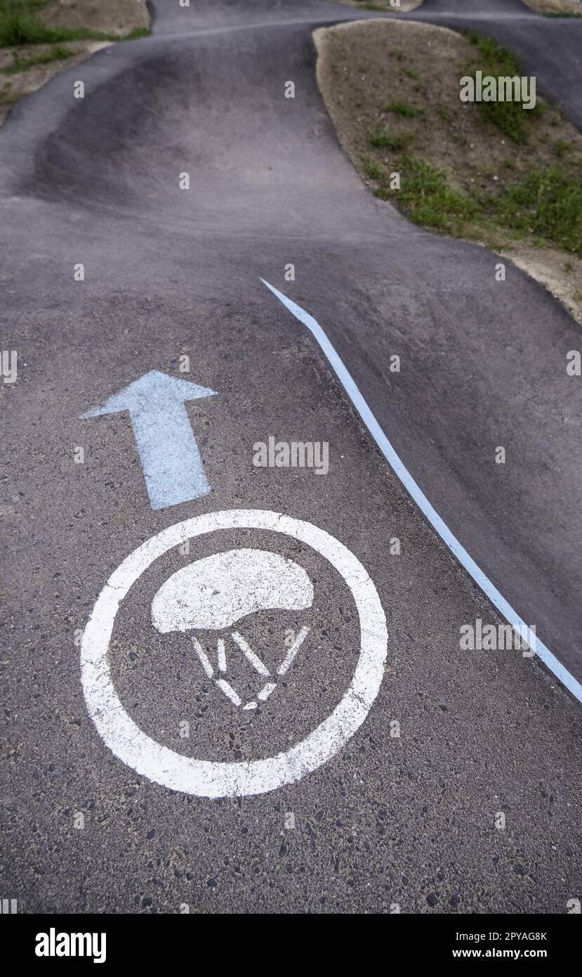 Helmet sign on asphalt Stock Photo - Alamy