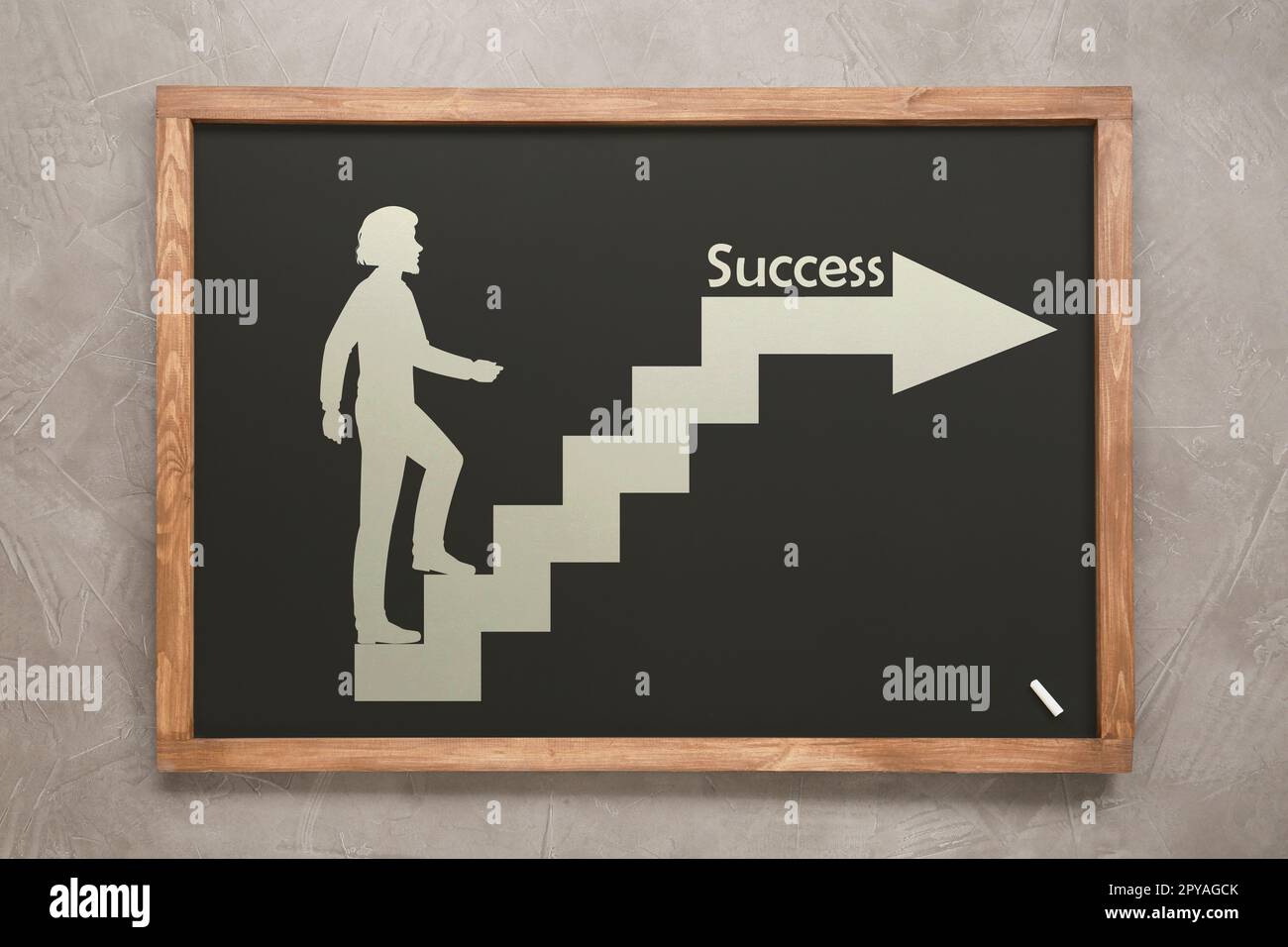 Person going up stairs drawn on chalkboard against grey background ...