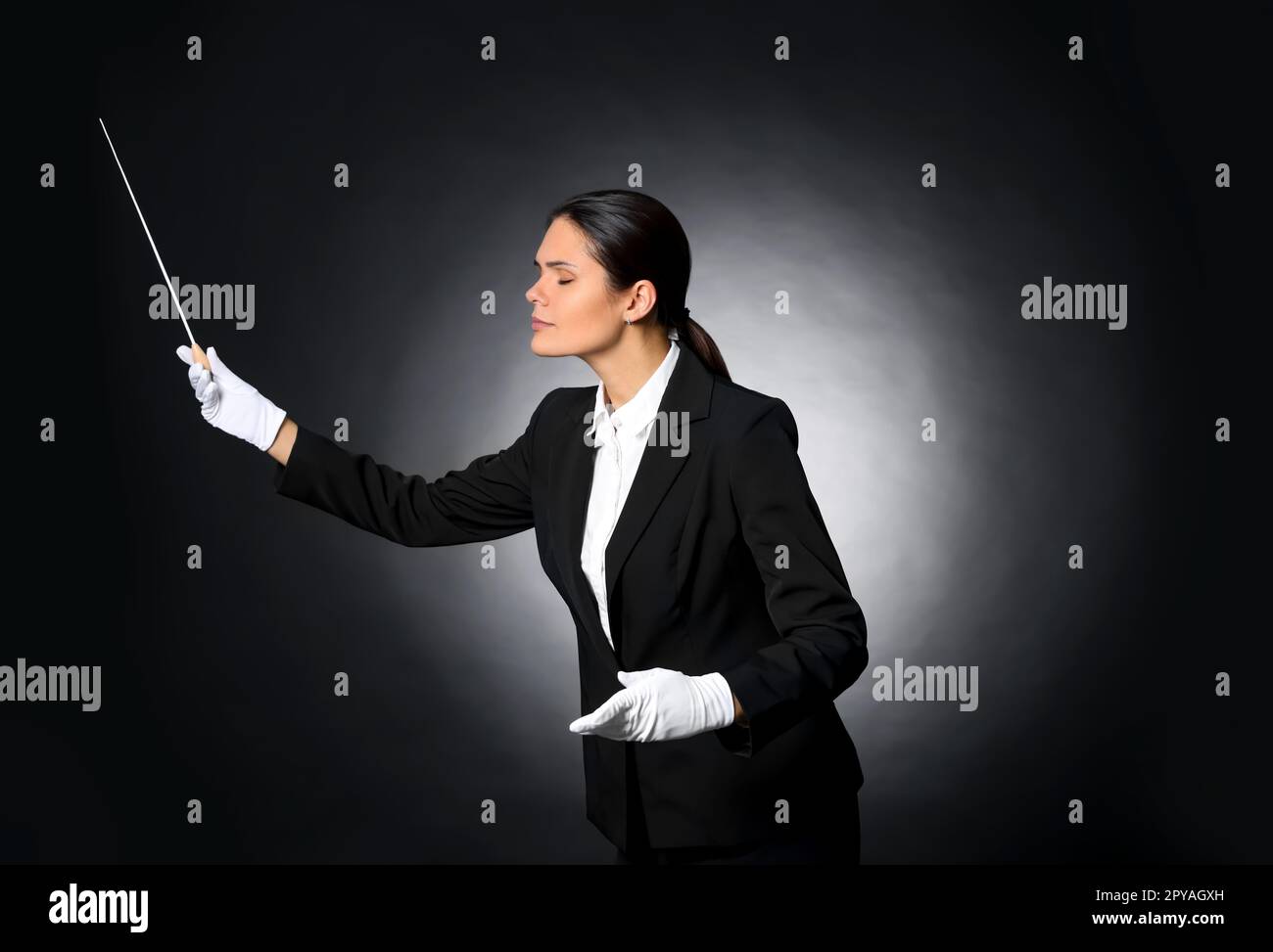 Professional conductor with baton on black background Stock Photo - Alamy