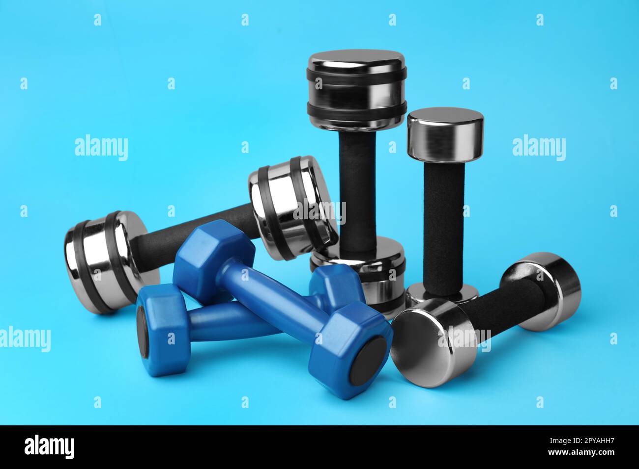 Many different stylish dumbbells on light blue background Stock Photo ...