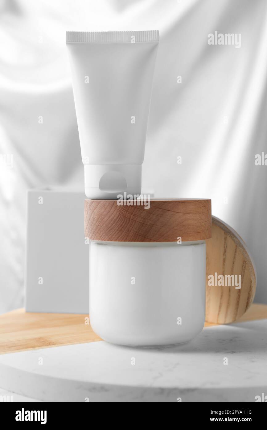 Jar and tube of hand cream on board Stock Photo - Alamy