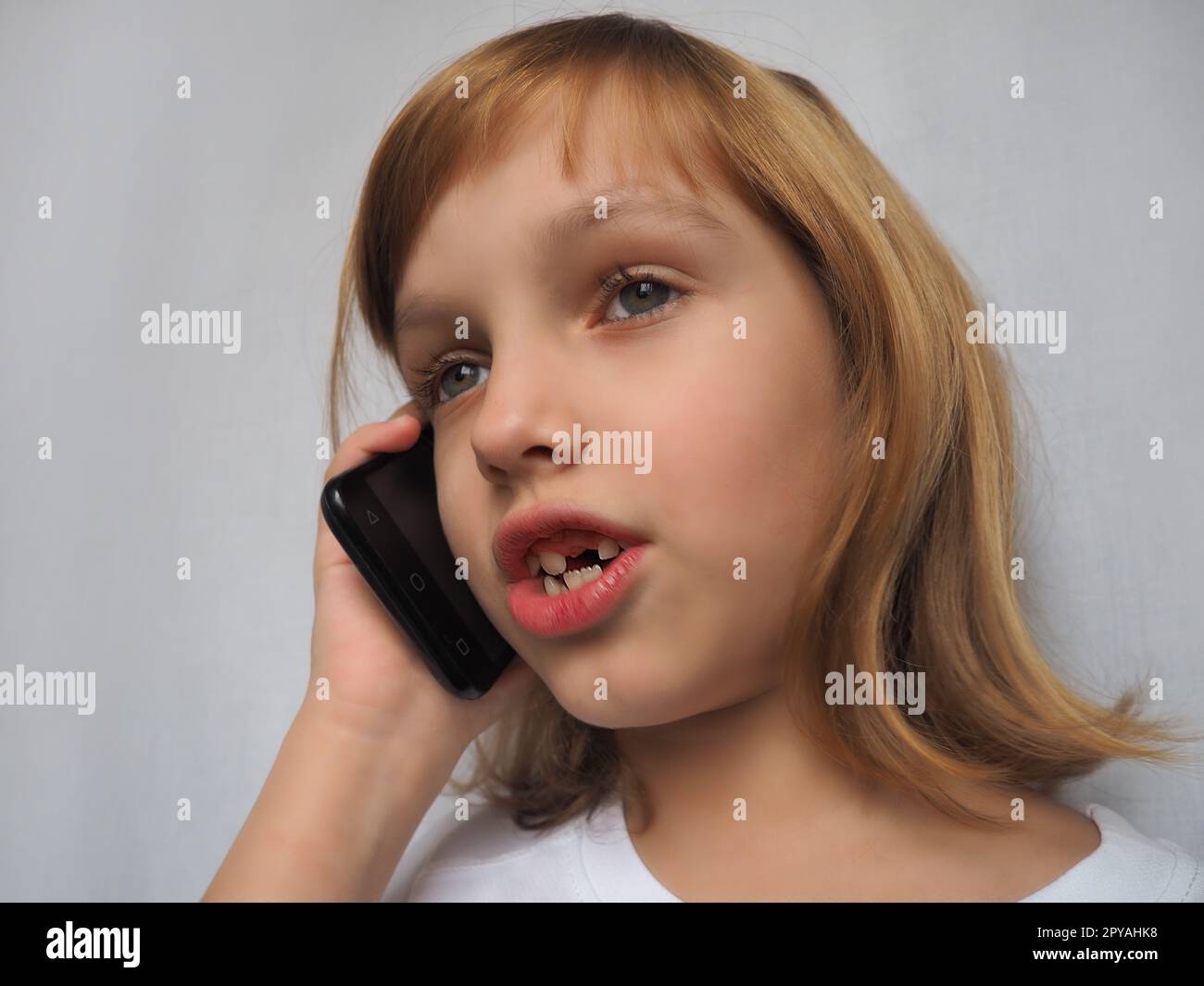 A 7-year-old girl without a front tooth. The child smiles, looks to the ...