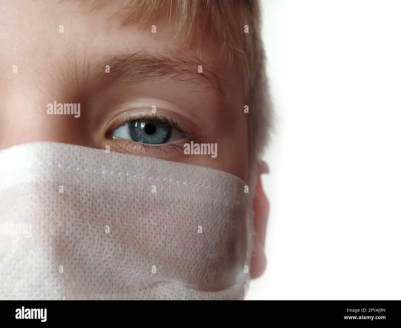 Masked child. A handsome boy with blond hair and gray eyes. Close-up of ...