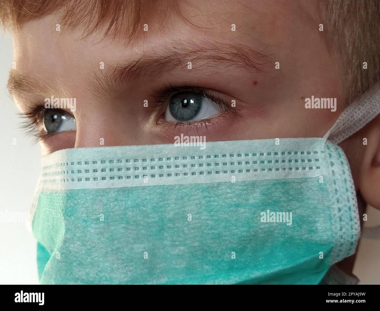 Masked child. The face of a 7-year-old boy in a protective surgical ...