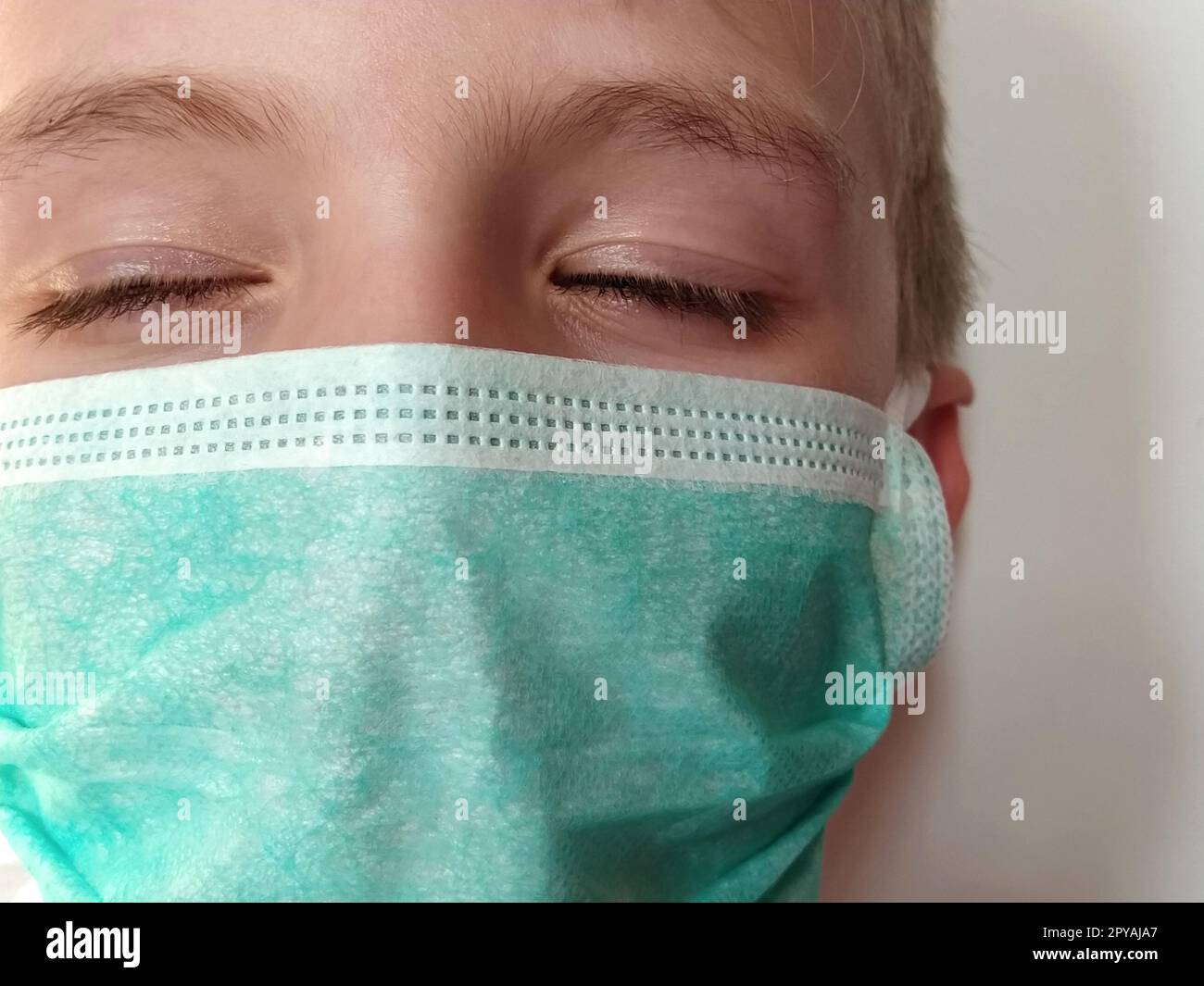 Masked child. The face of a 7-year-old boy in a protective surgical ...