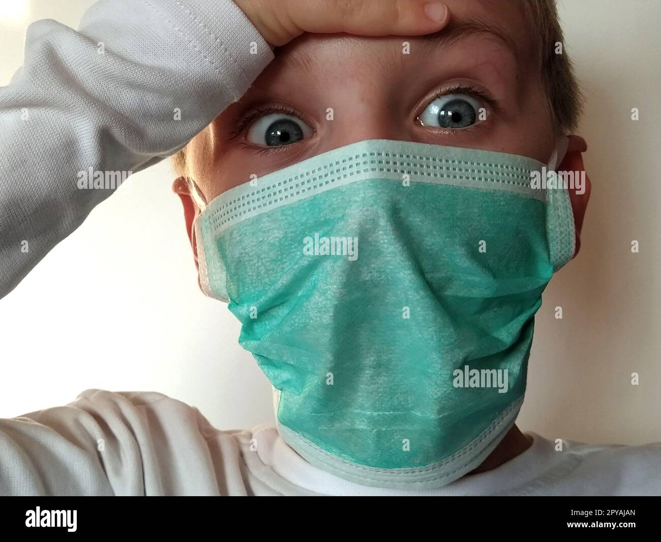 Masked child. The face of a 7-year-old boy in a protective surgical ...