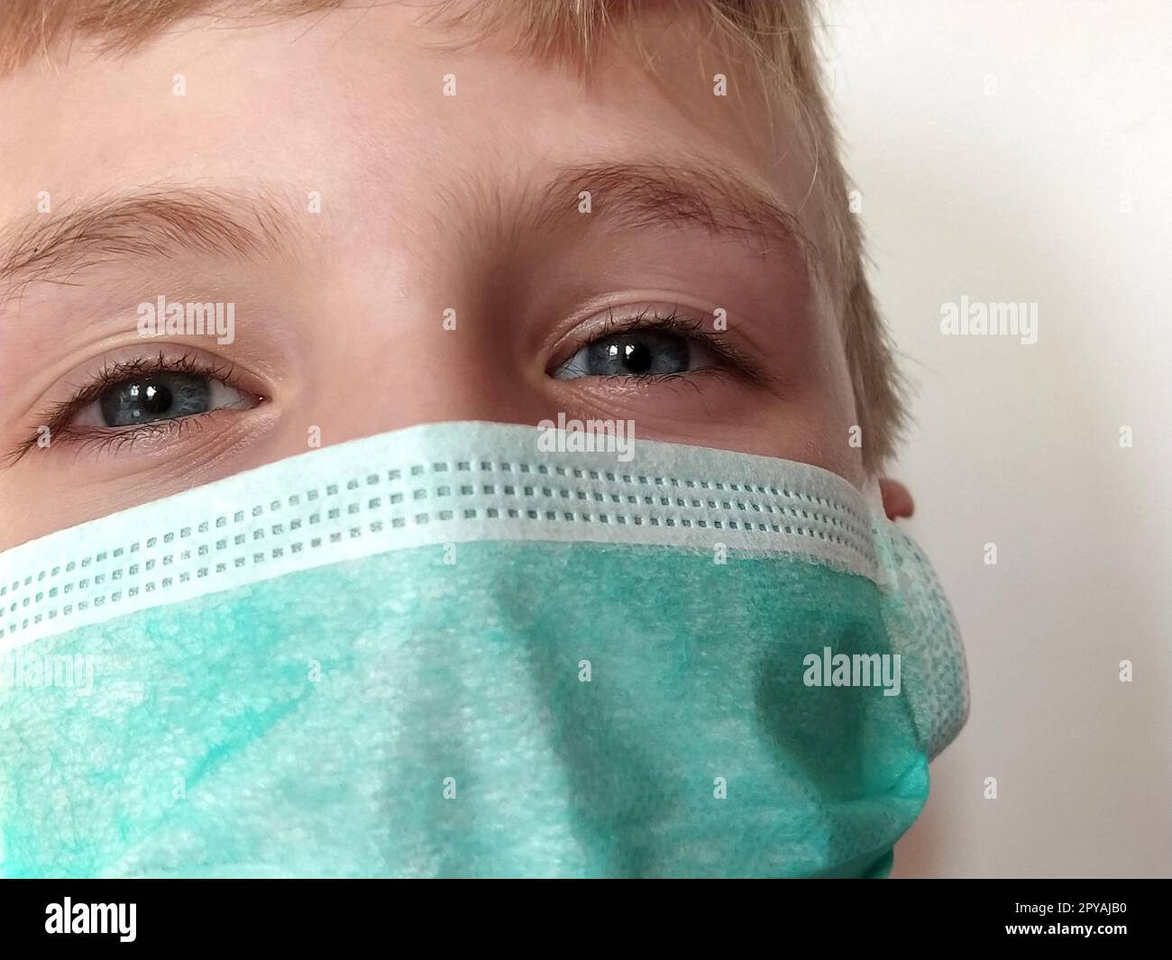 Masked child. The face of a 7-year-old boy in a protective surgical ...