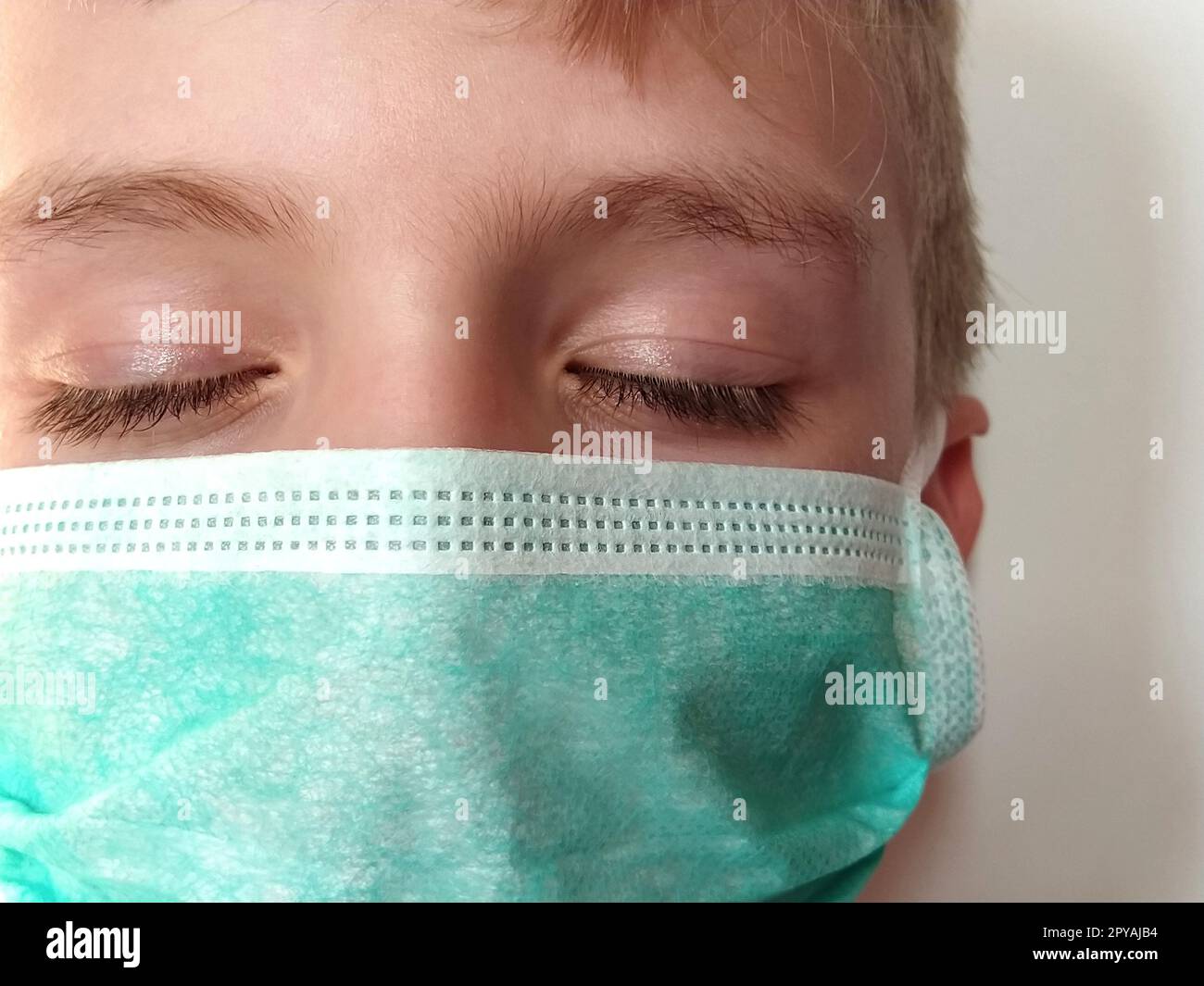 Masked child. The face of a 7-year-old boy in a protective surgical ...