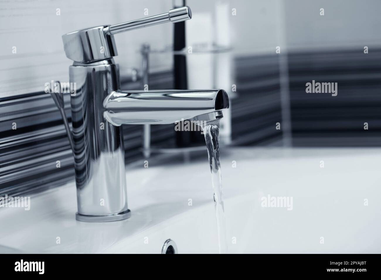Stream of water flowing from tap in bathroom Stock Photo - Alamy