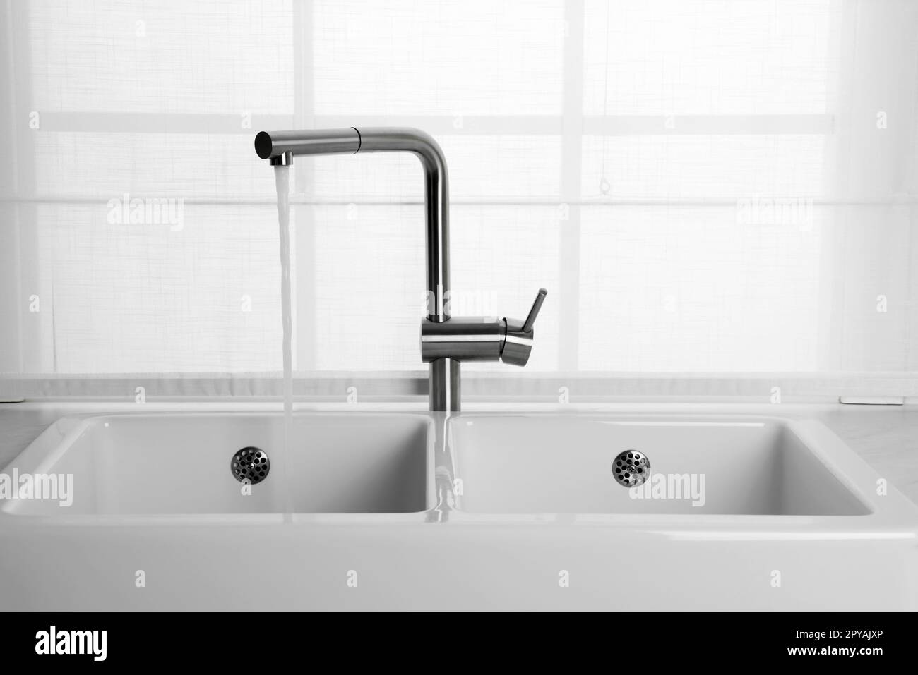 Stream of water flowing from tap in kitchen Stock Photo - Alamy