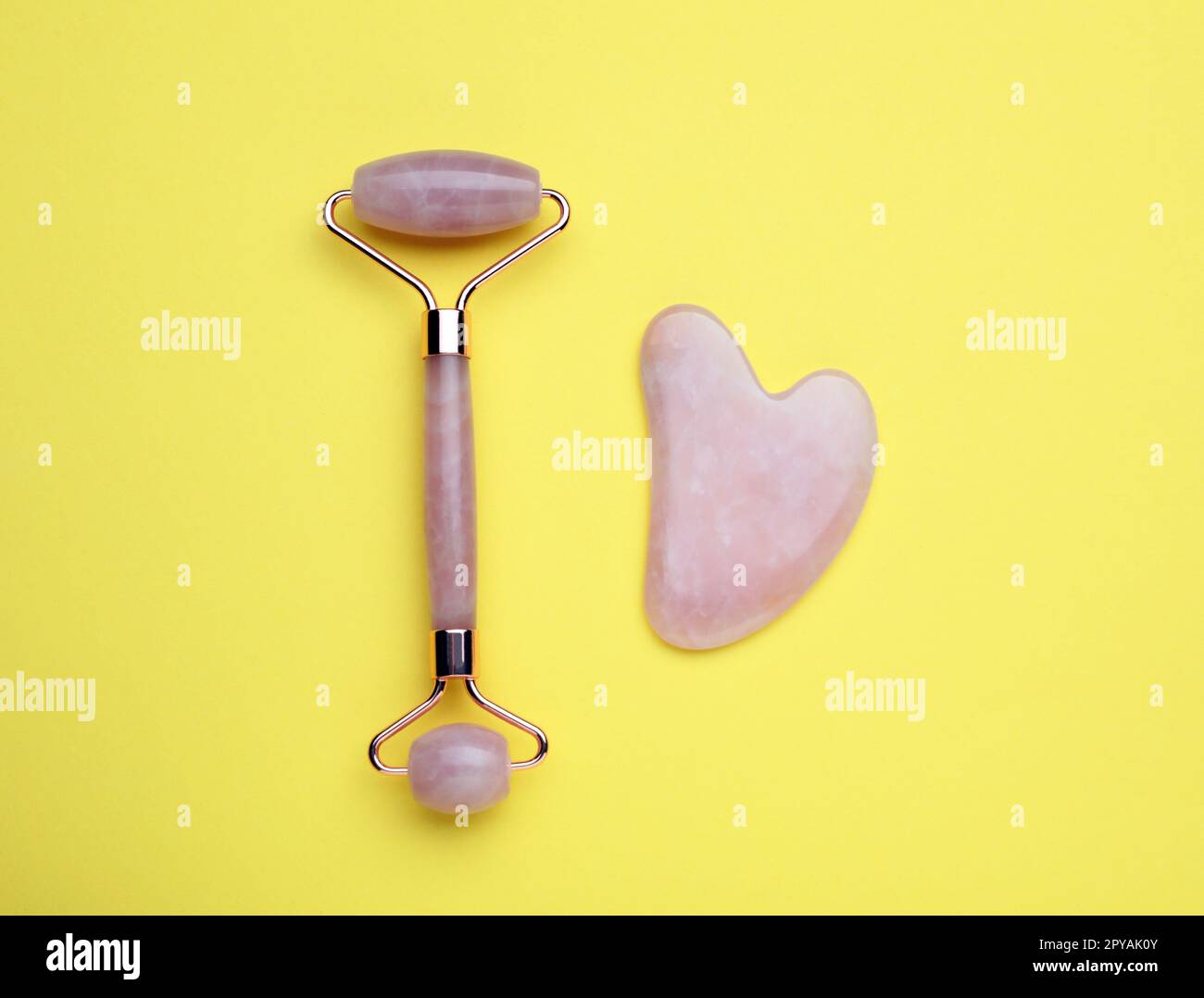 Gua sha stone and face roller on yellow background, flat lay Stock ...