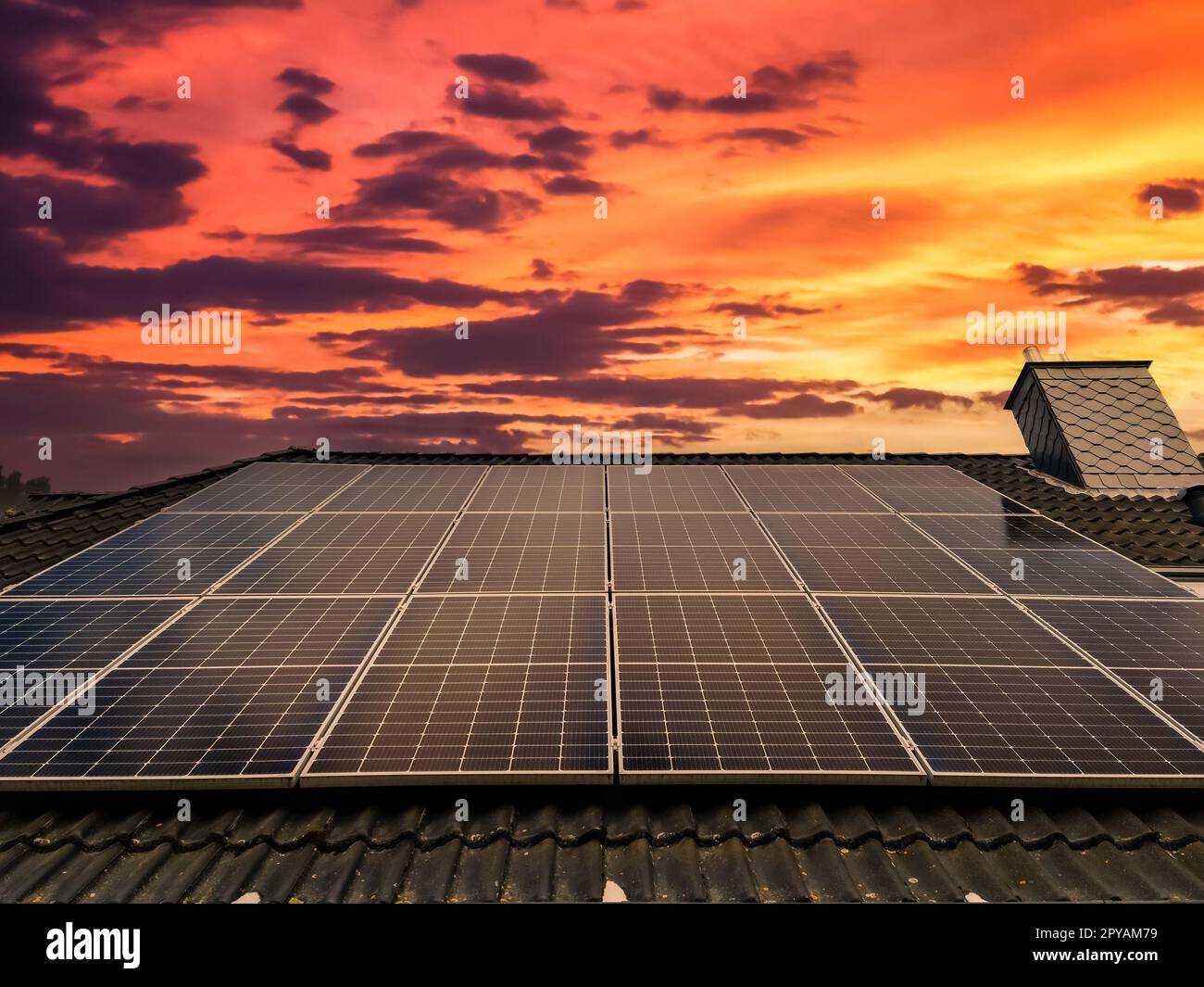 Colorful sunset on solar panels producing clean energy on a roof of a ...