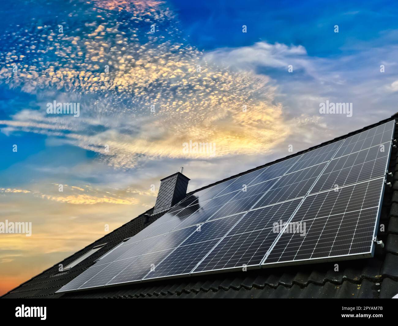 Colorful sunset on solar panels producing clean energy on a roof of a ...