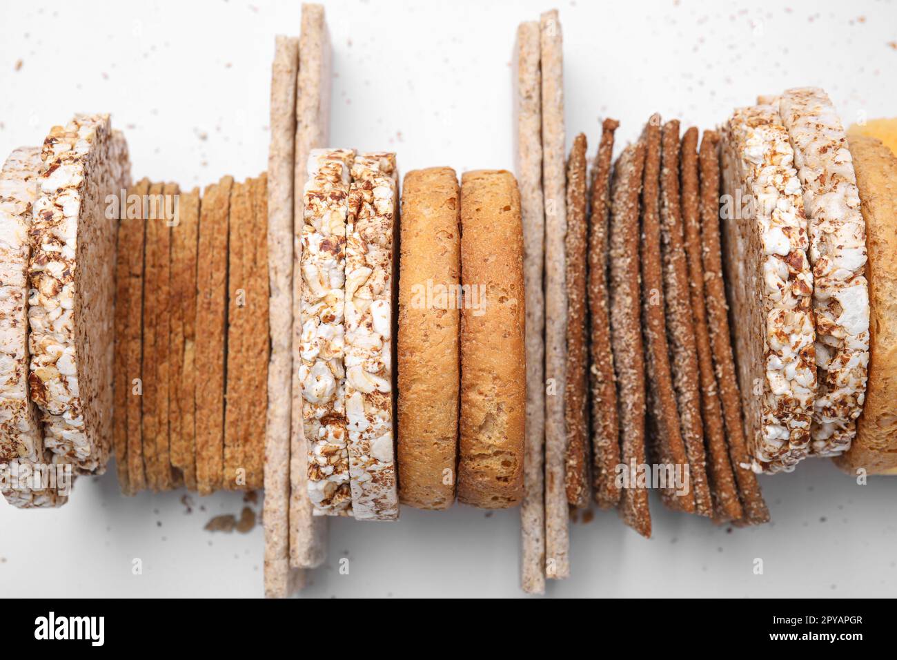 Many fresh rye crispbreads, crunchy rice cakes and rusks on white ...