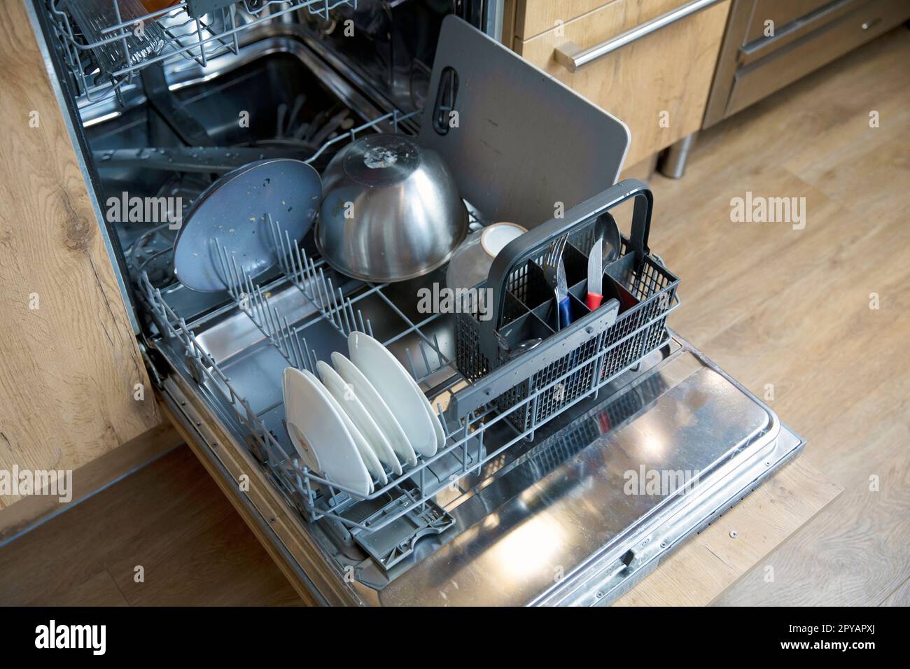 Stack of dirty dishes in dishwasher needs to be cleaned, open door with ...