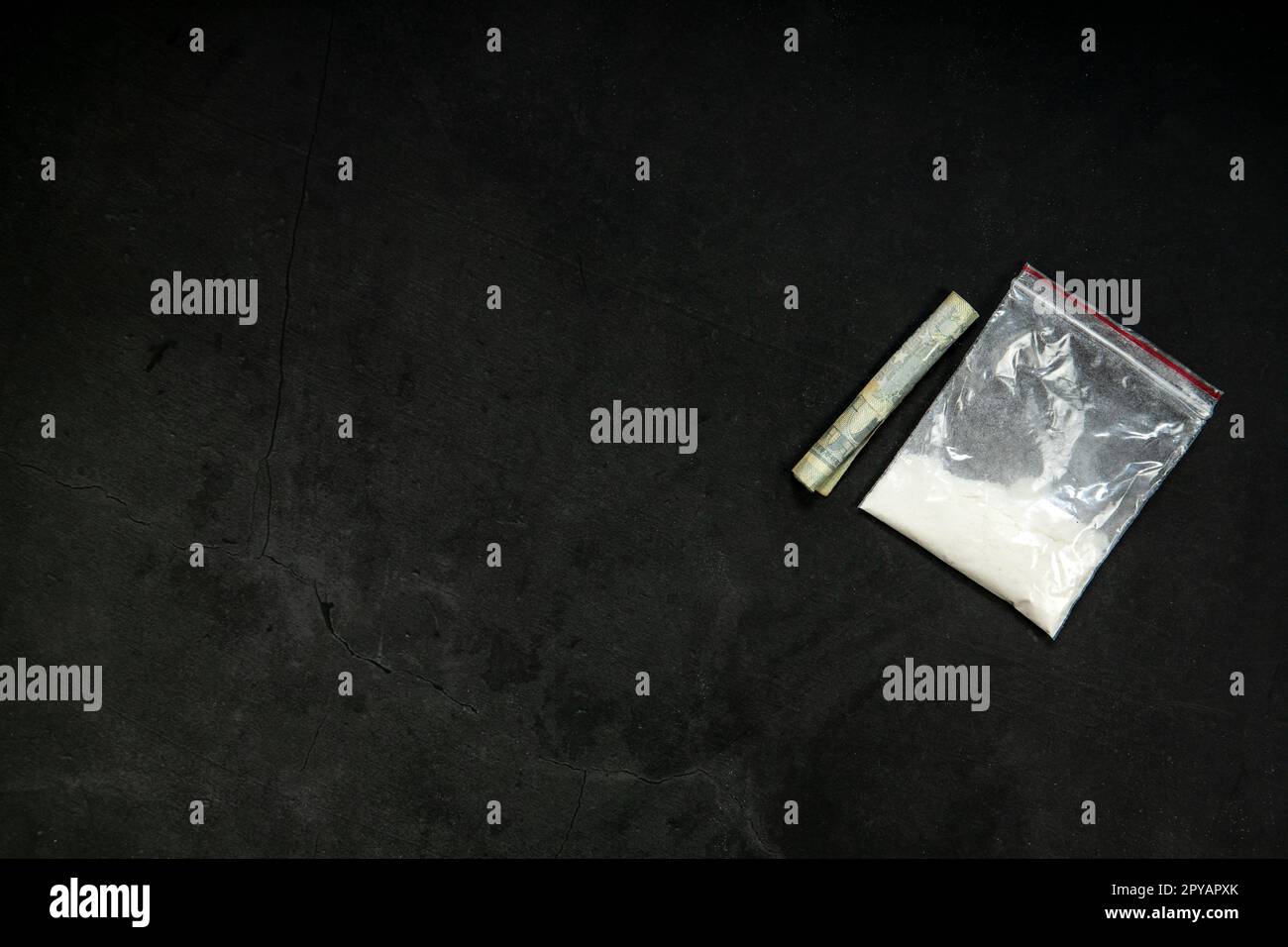 Cocaine powder lines, rolled banknote and drugs in plastic bag pocket ...
