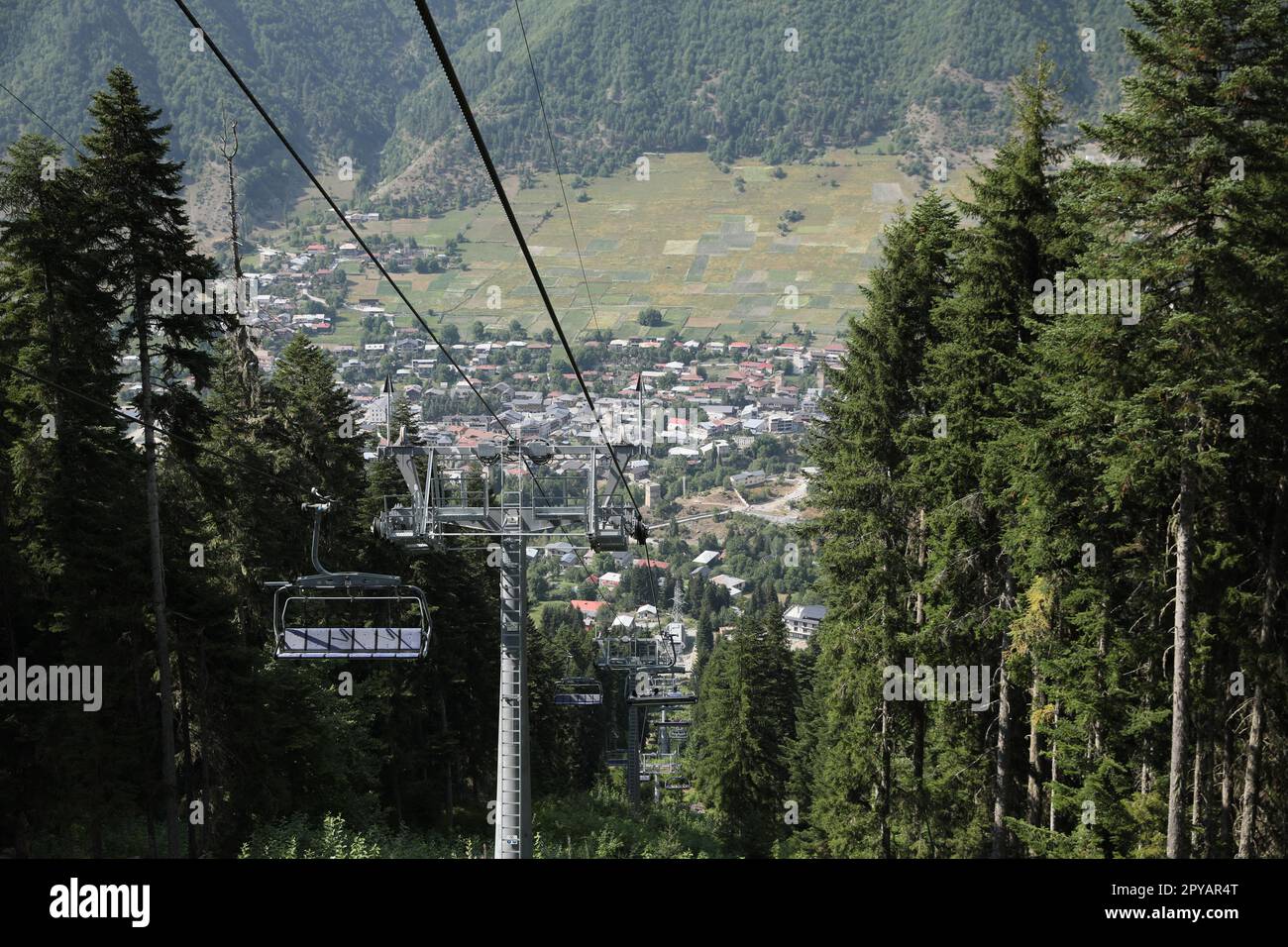 Picturesque view of beautiful trees and cableway with seats Stock Photo ...